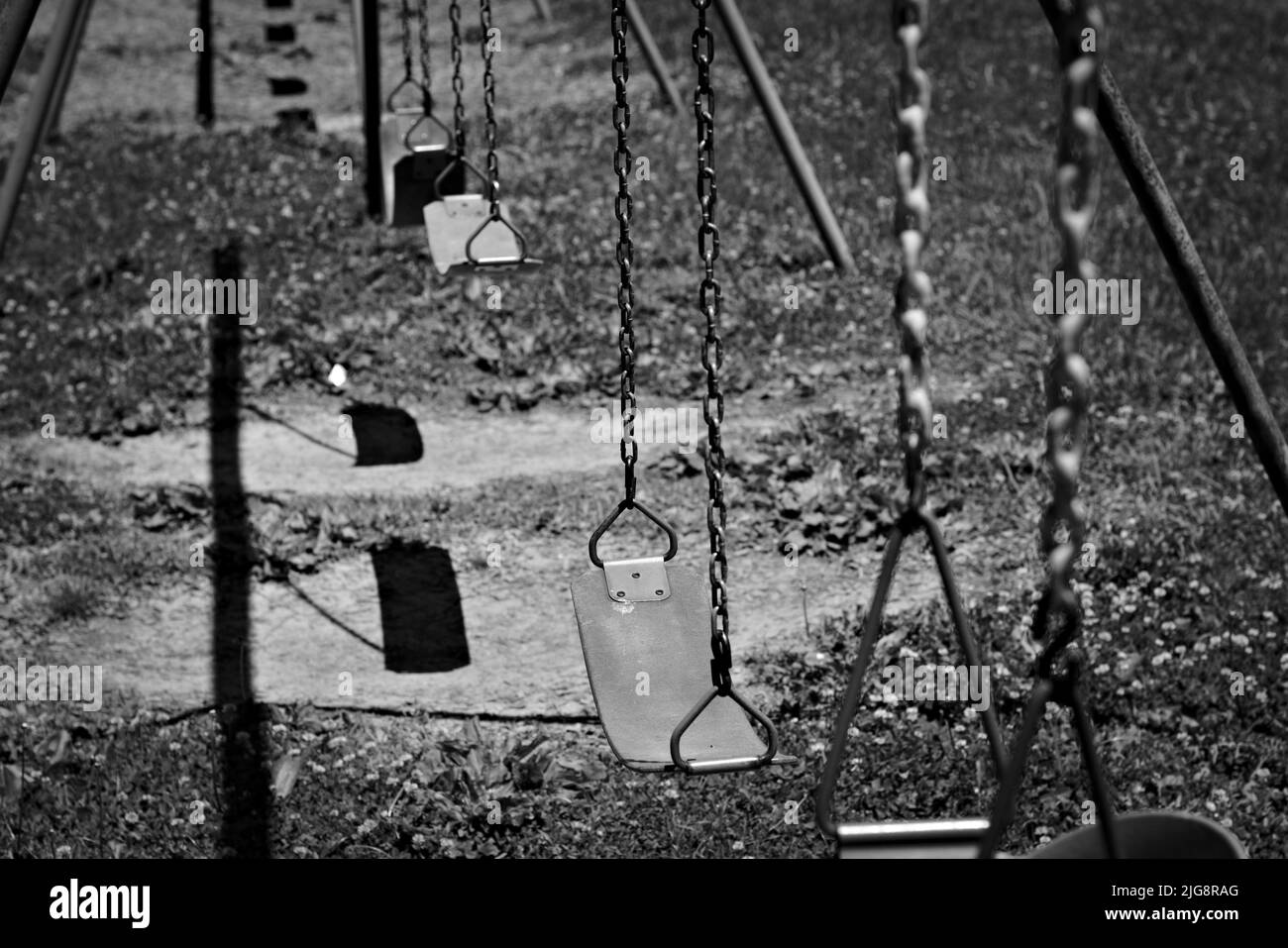A grayscale shot of swings at the playground in Washington ...