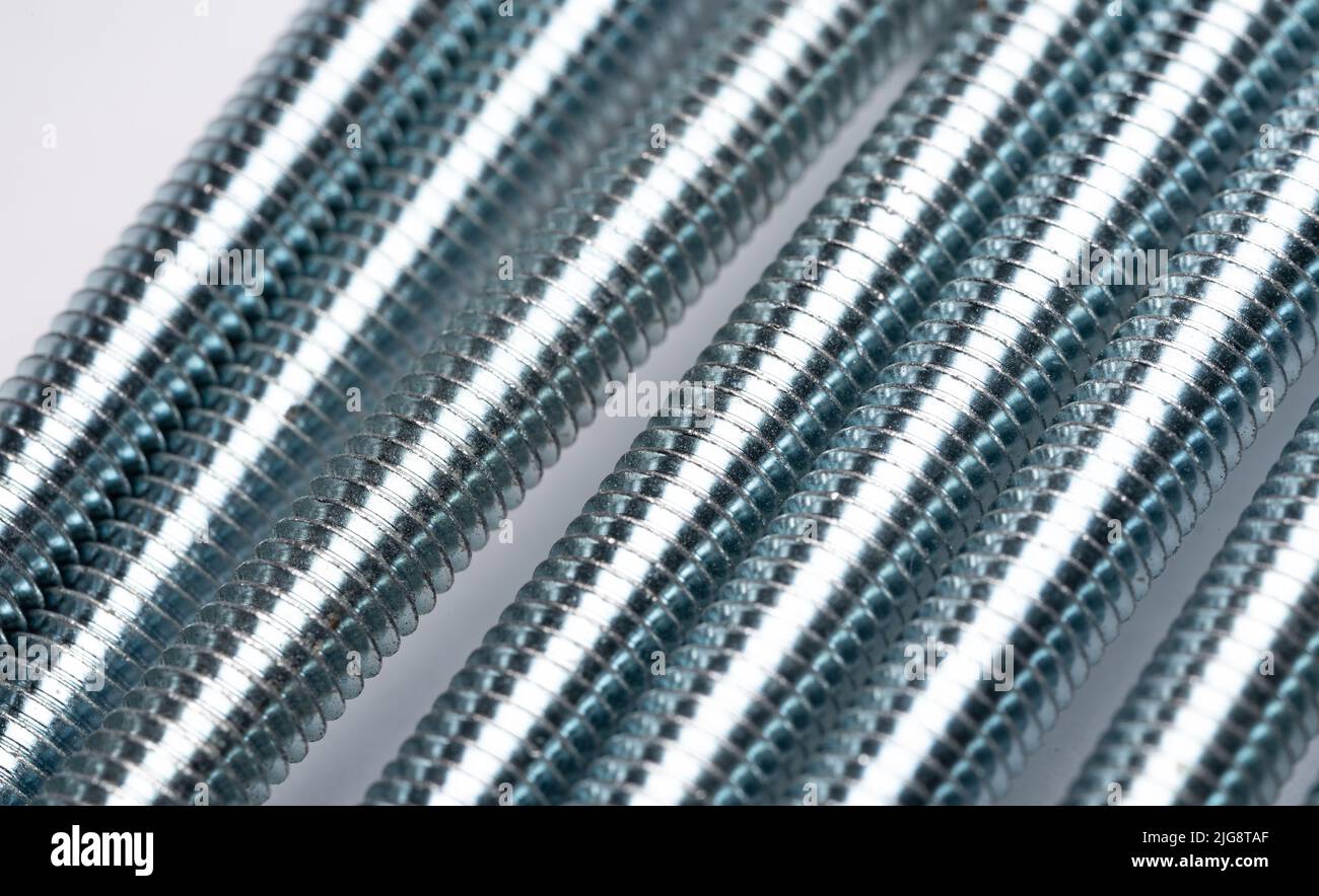 The threaded bolts are stacked side by side to create an abstract ...