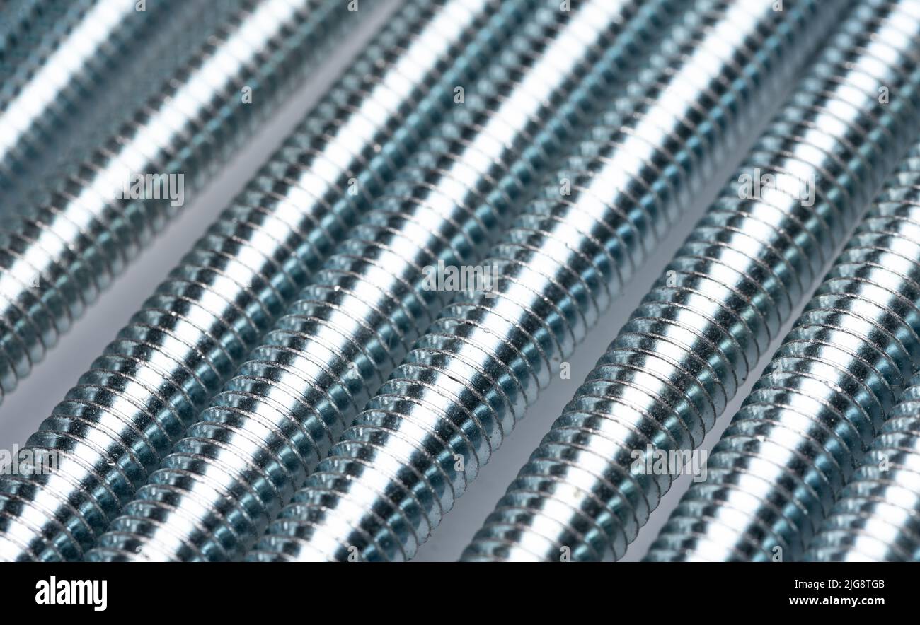 The threaded bolts are stacked side by side to create an abstract ...