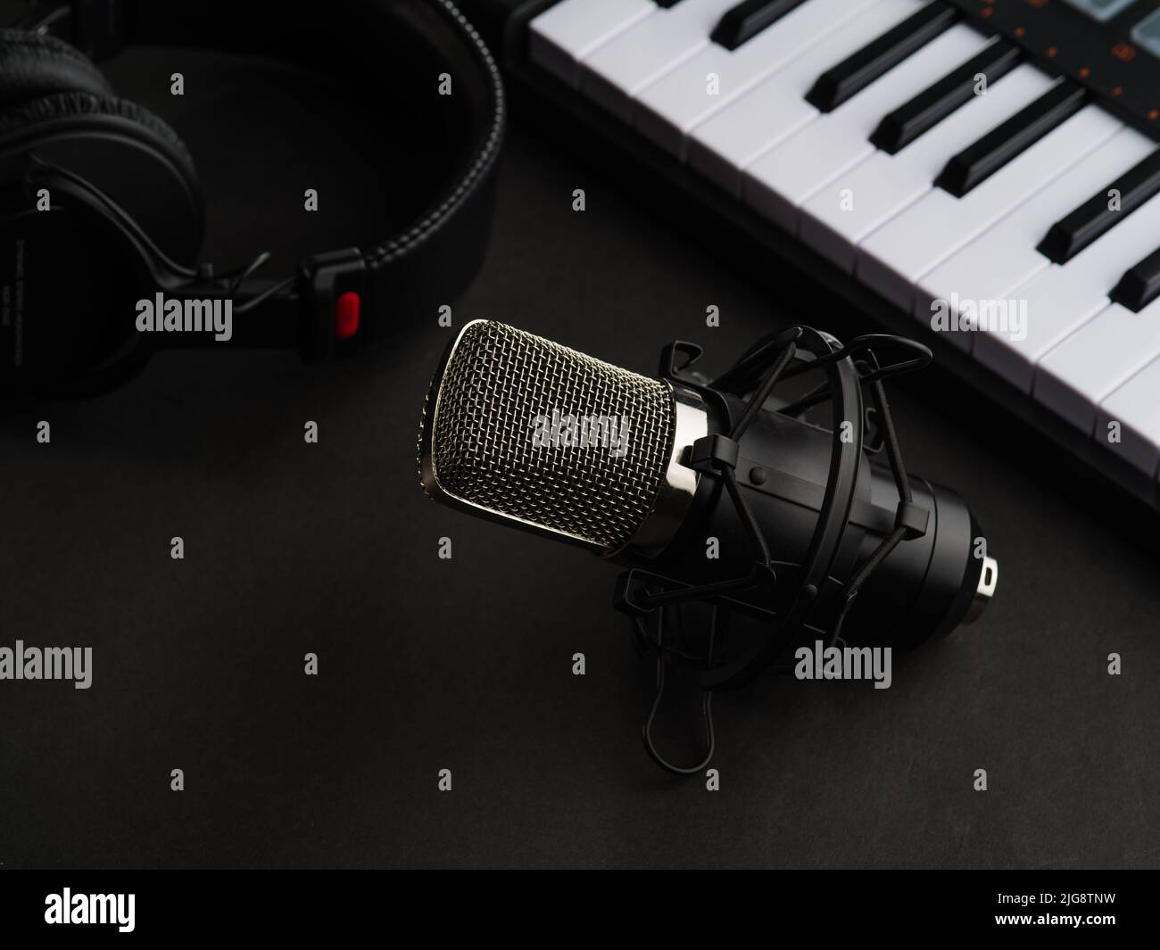 Studio headphones, a microphone and a modern synthesizer-midi keyboard ...