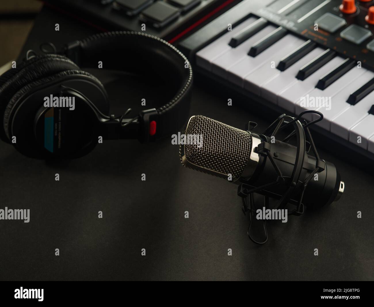 Studio microphone, studio headphones, modern synthesizer-midi keyboard ...