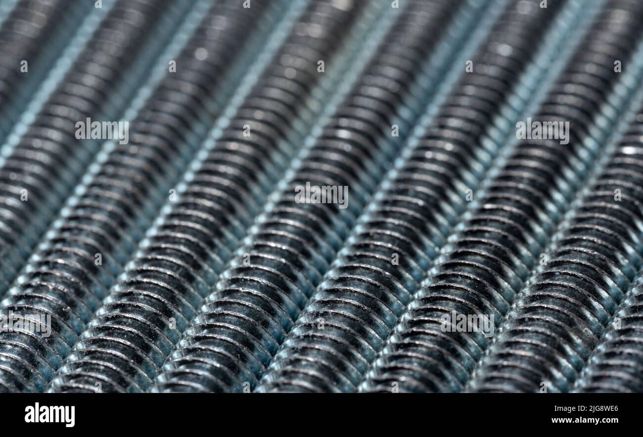 The threaded bolts are stacked side by side to create an abstract ...