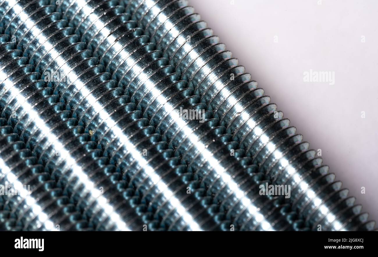 The threaded bolts are stacked side by side to create an abstract ...