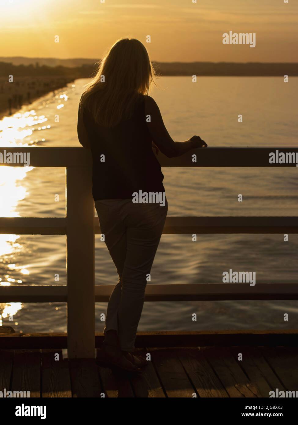 Woman watching the sunset Stock Photo - Alamy