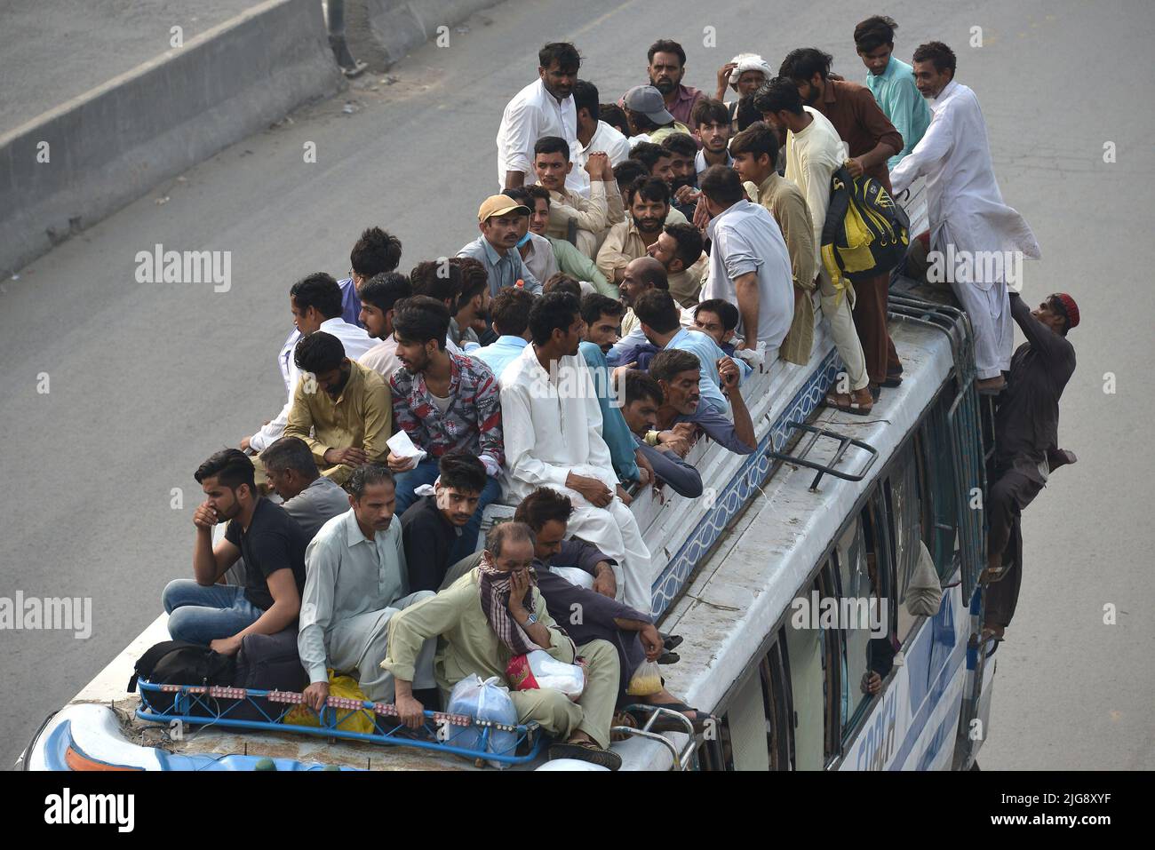 Pakistani people boarding roof top on a crowded bus as they travel to ...