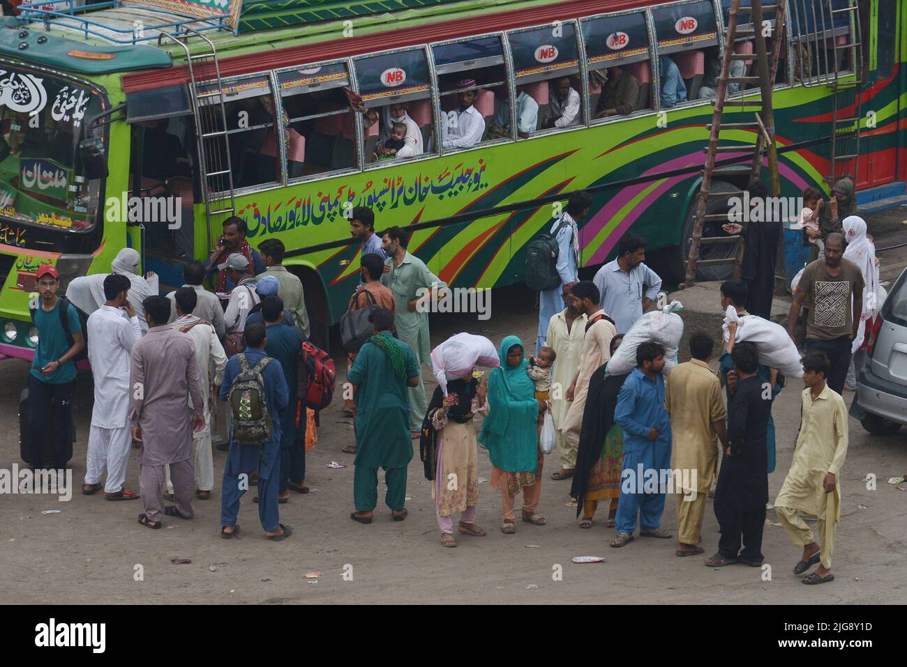 Pakistani people boarding roof top on a crowded bus as they travel to ...