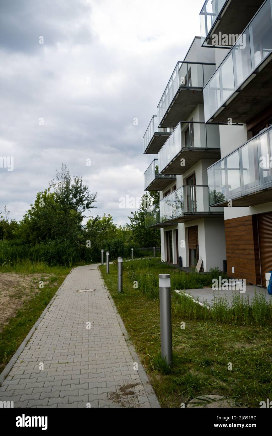 A vertical view of a small footpath next to a modern apartment building ...
