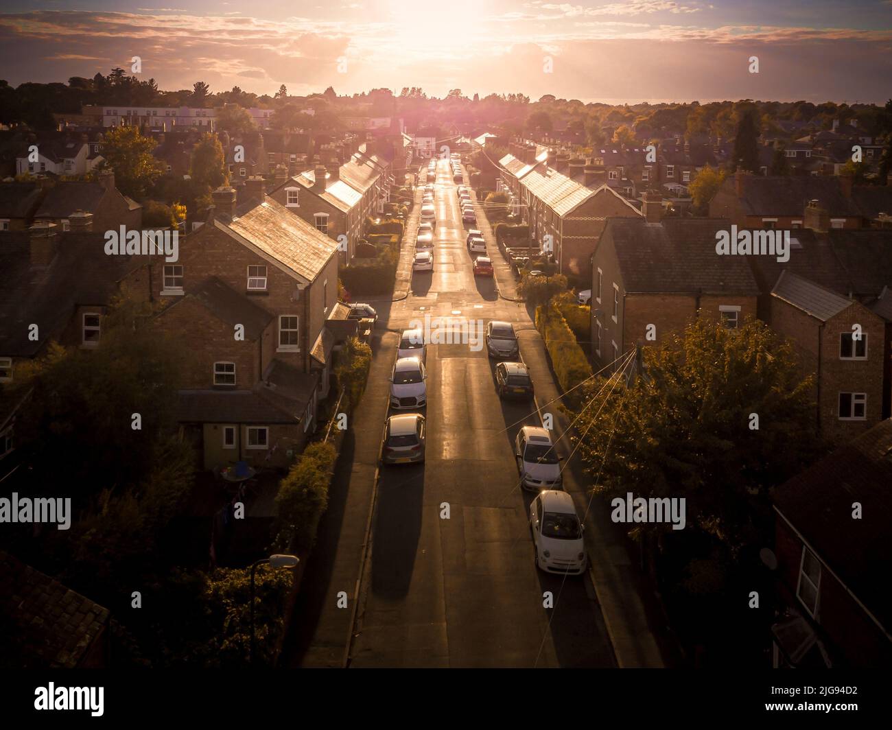 A drone view of a Victorian terraced housing street at sunset ...
