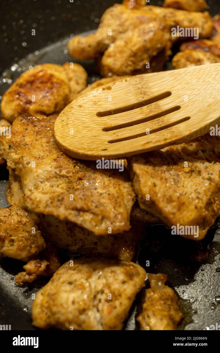 A vertical view of the meat frying process in the black pan -food ...