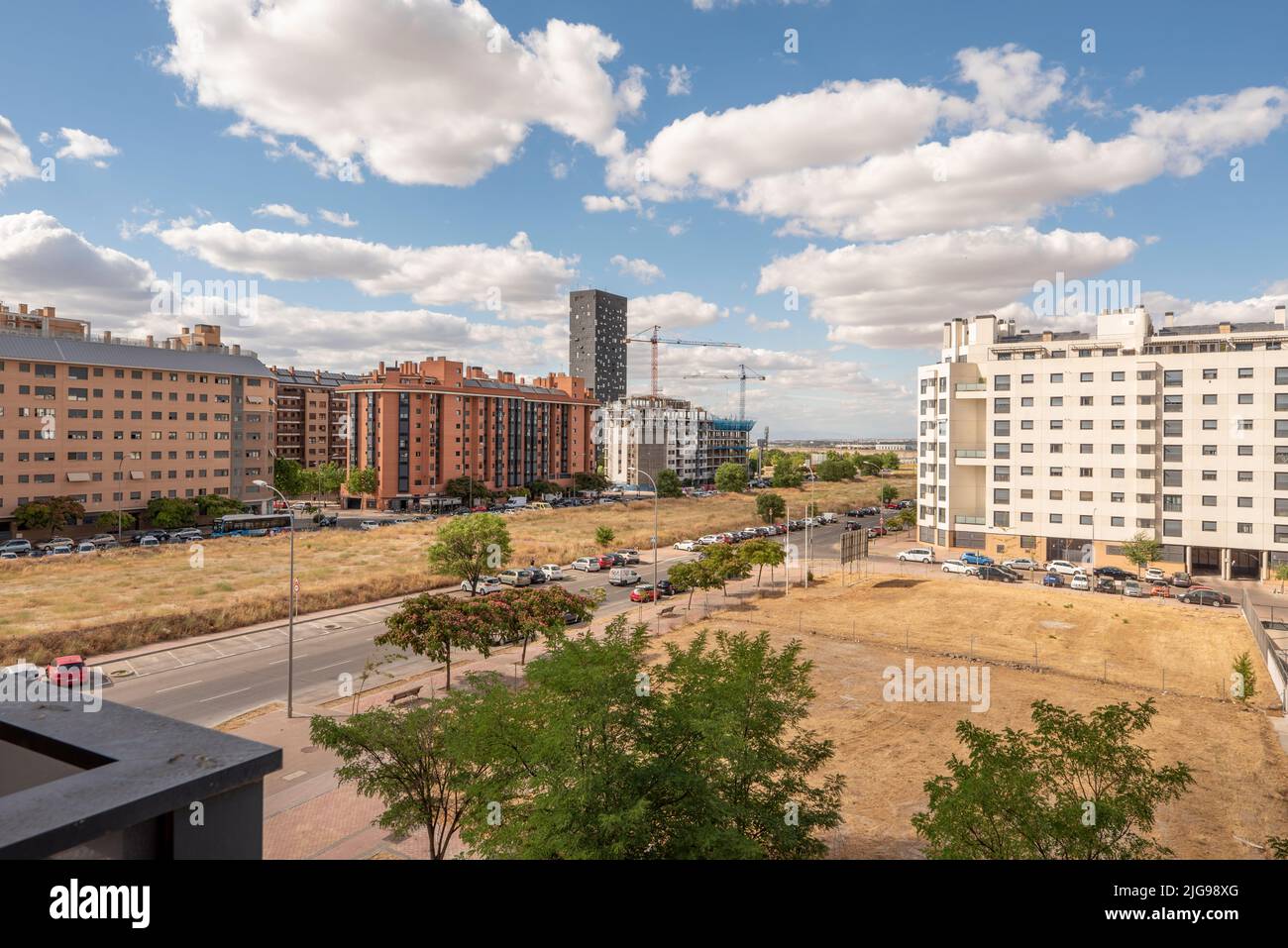 Facades of modern buildings and empty lots between them with blue skies ...