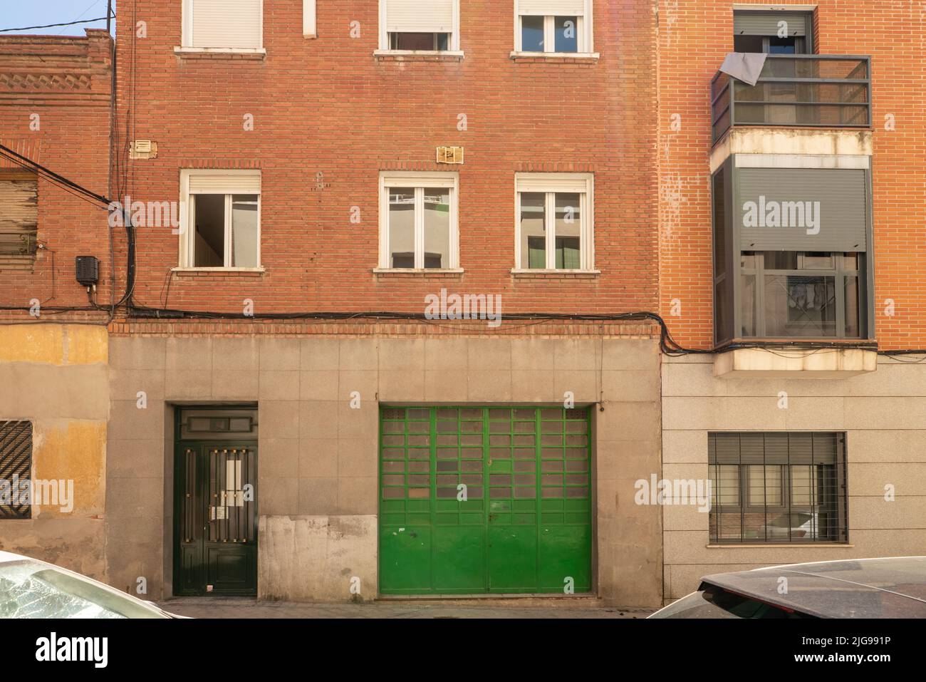 Facade of humble residential buildings with green gates garage Stock ...