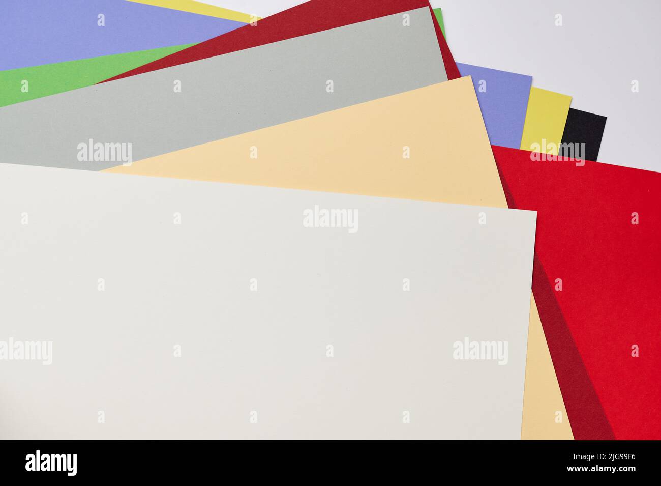 cardboard sheets in different colors, in front a white one with copy ...