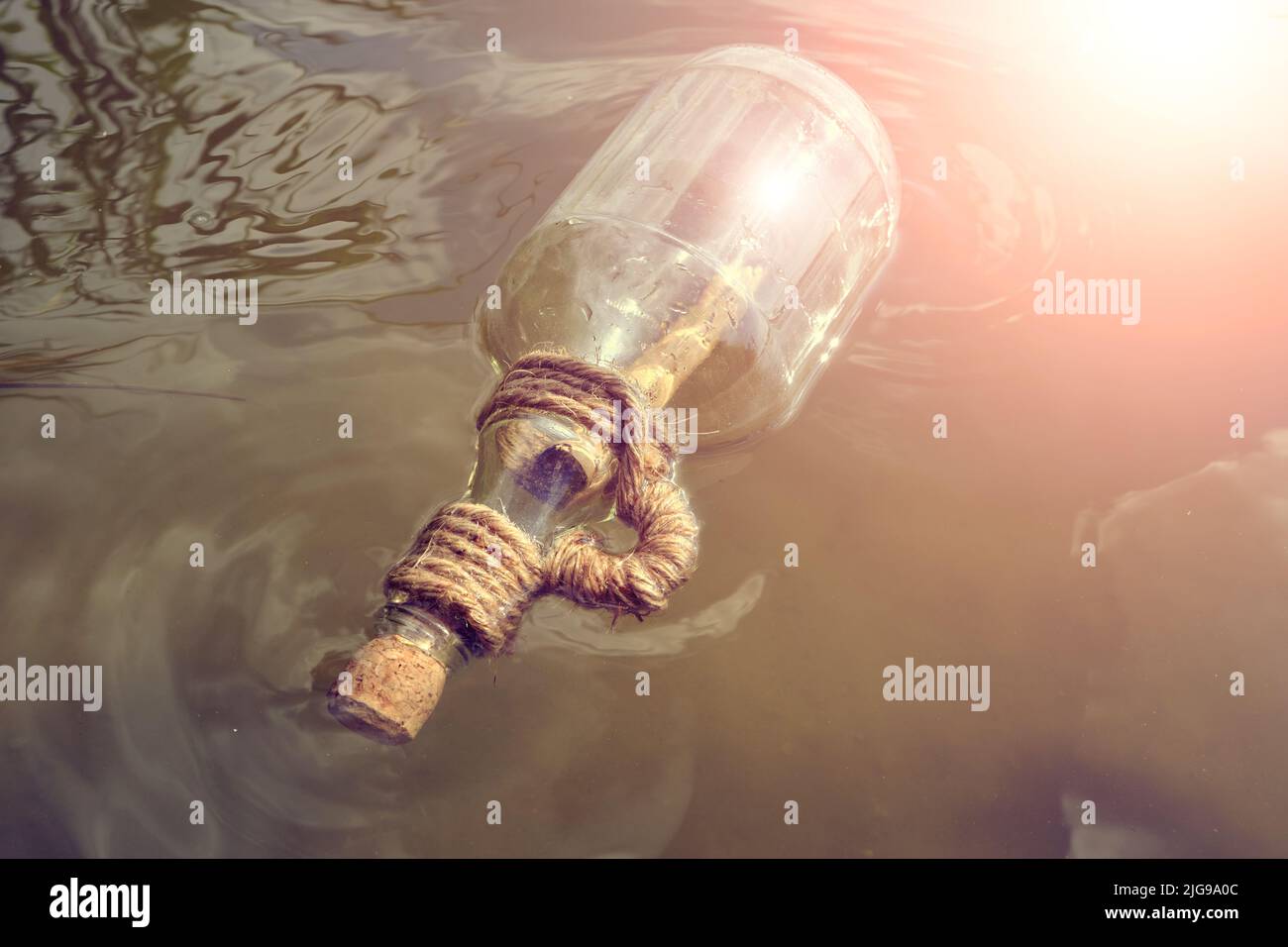 Bottle floating on water with a rolled letter inside.Message call for ...