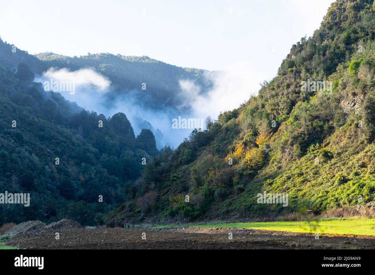 Sun hits hillside through clouds and between Southern Alp peaks at ...