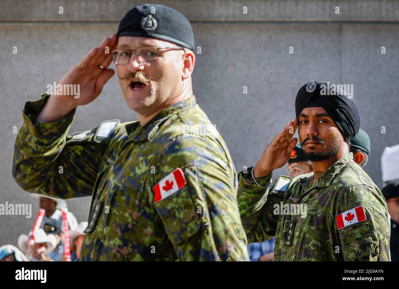 A Sikh member, right, of the Canadian Forces salutes while marching ...