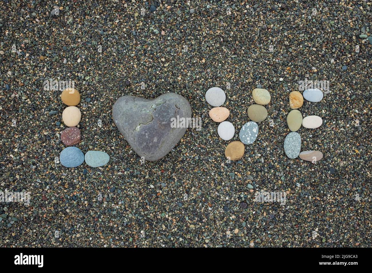 Word love made from stones on sandy beach. Romantic mood during ...