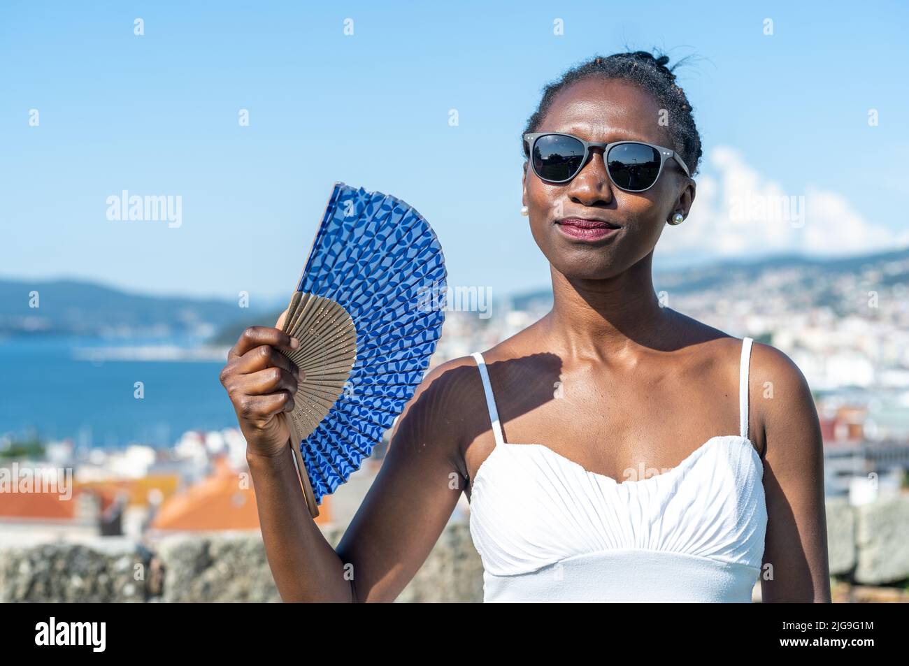 Woman fanning herself on a hot day Blurred city view background Stock ...