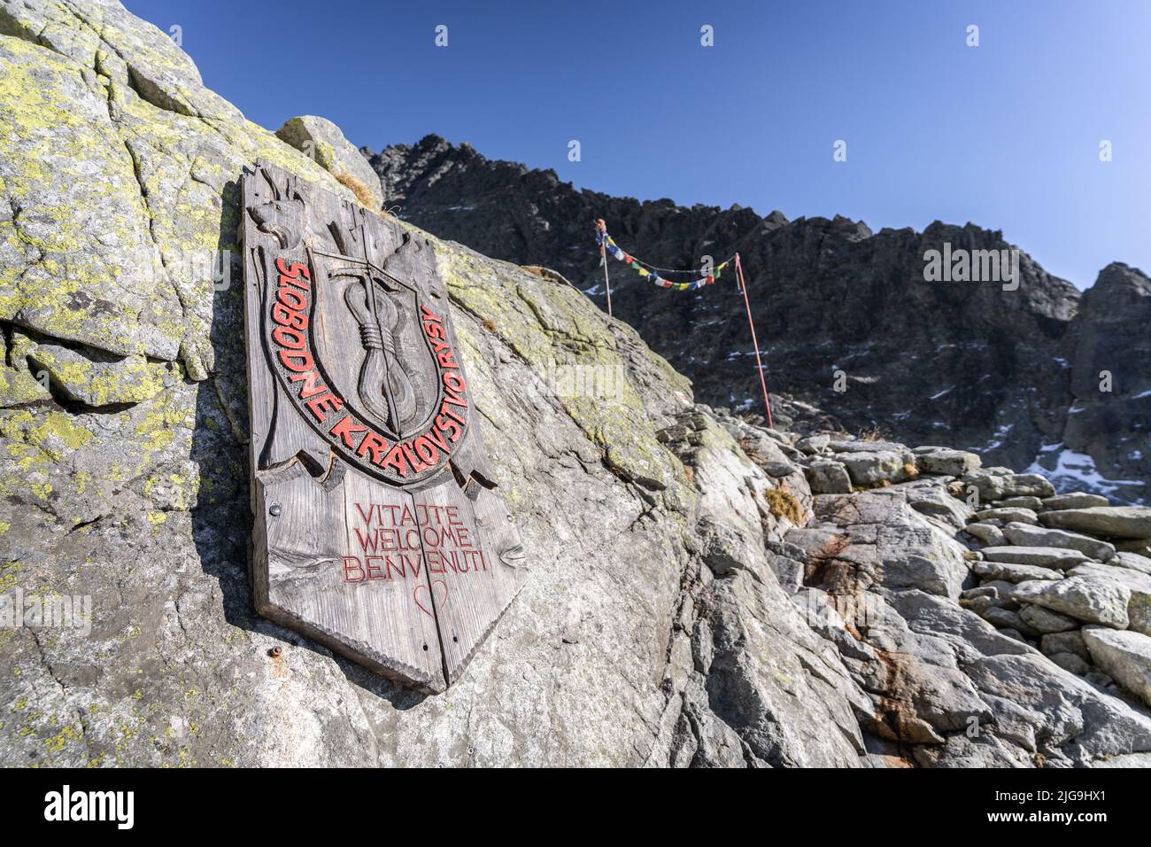 Welcome sign in alpine environment before the entrance to the hut ...