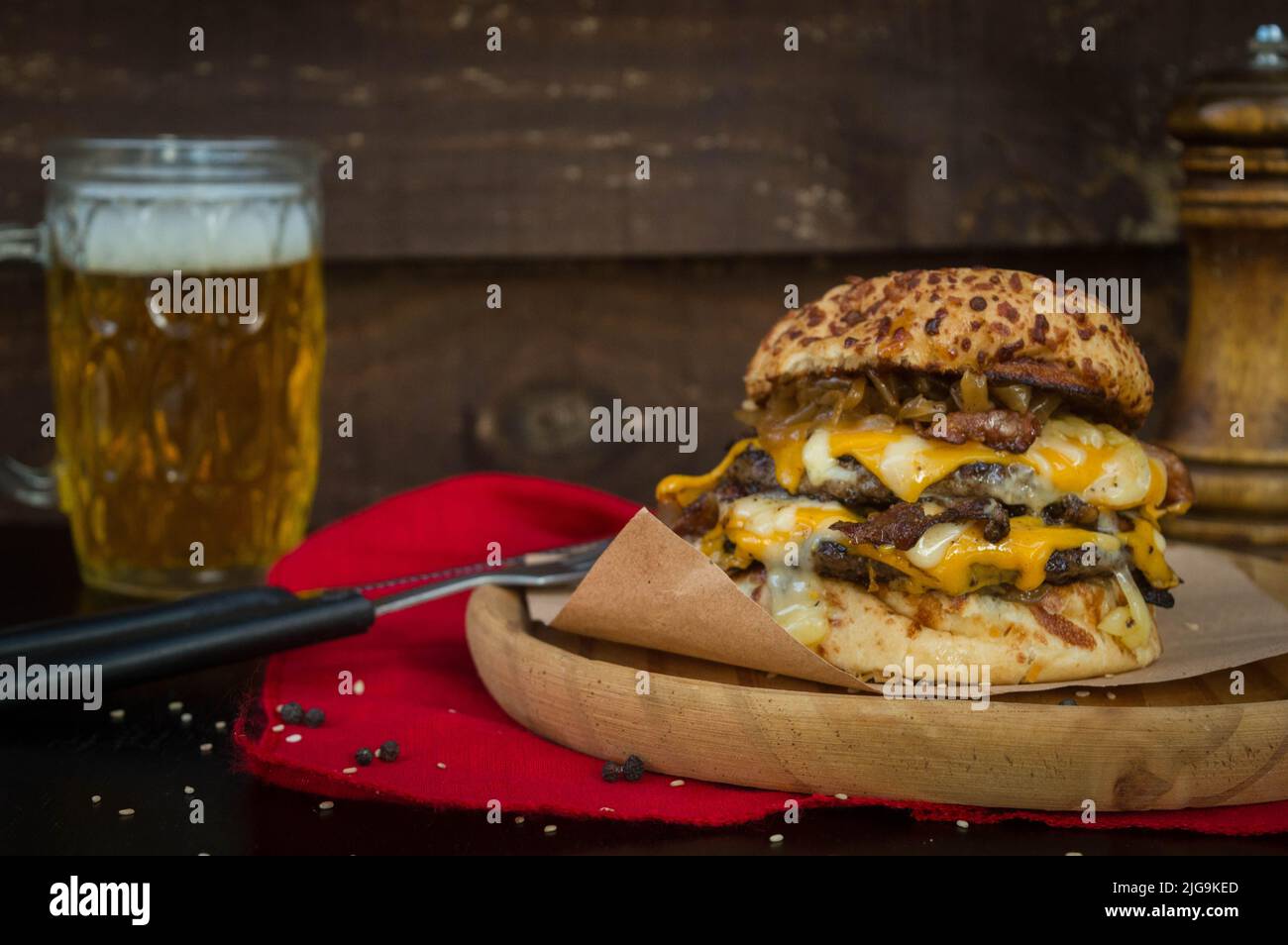 A tasty cheesy hamburger and a mug of beer on a table Stock Photo - Alamy