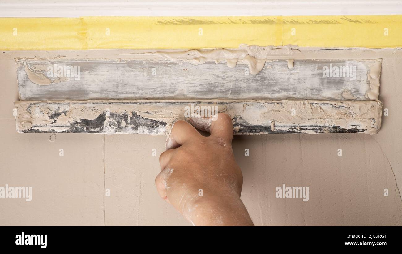 gypsum wall putty, leveling the walls with plaster with a spatula Stock ...