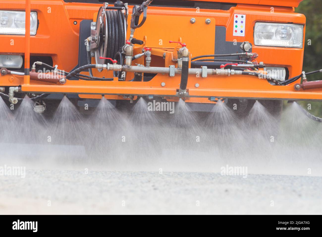 Big orange machine clears the asphalt with directed water streams Stock ...