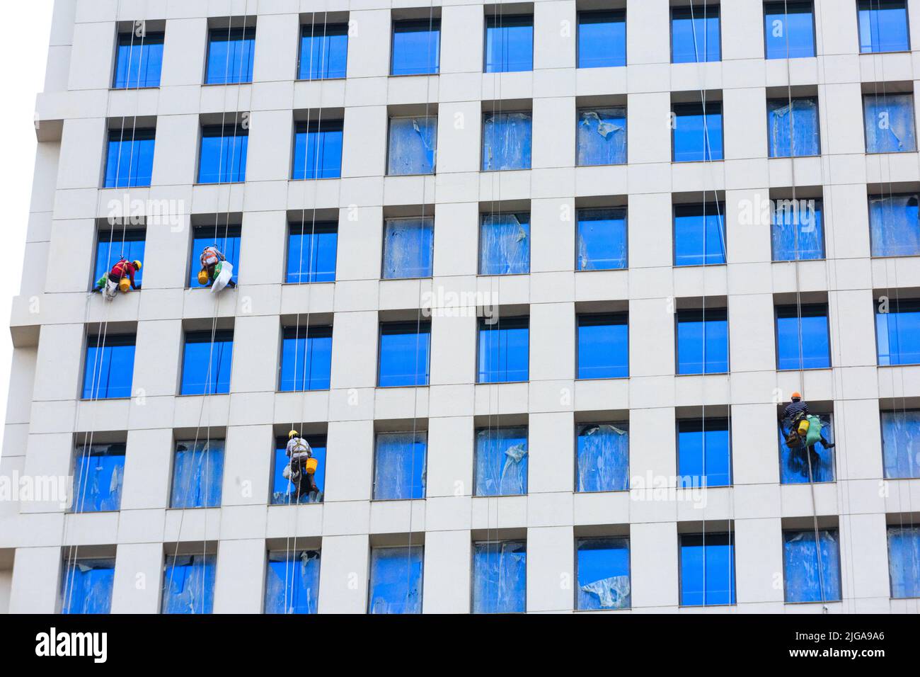 group of window washers hanging on ropes on a skyscraper facade Stock ...