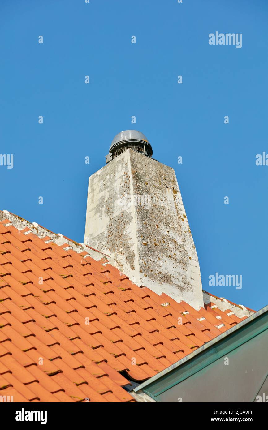 Concrete chimney designed on slate house roof or building outside ...