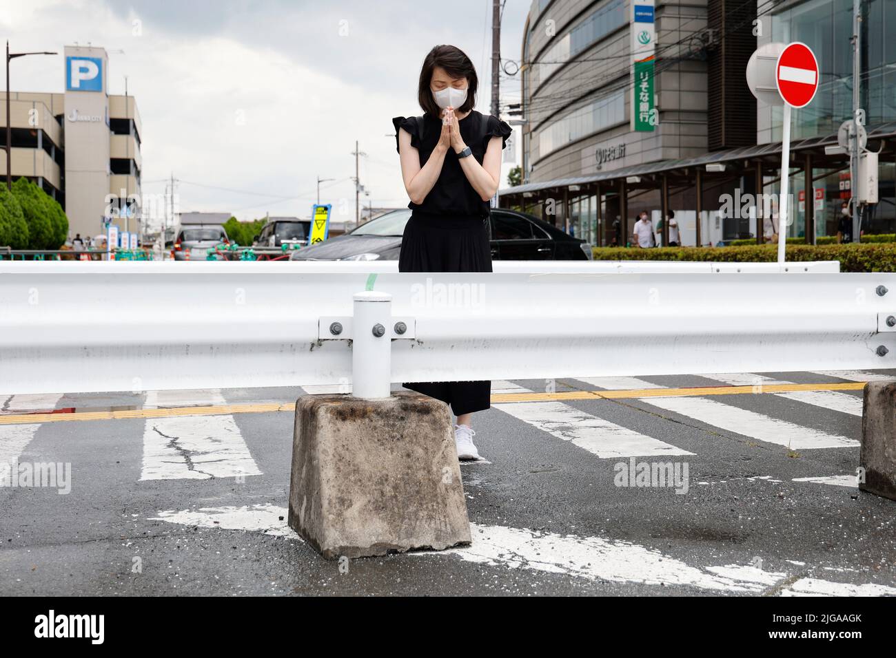 Nara, Nara, Japan. 9th July, 2022. A woman wearing a face mask offers a ...