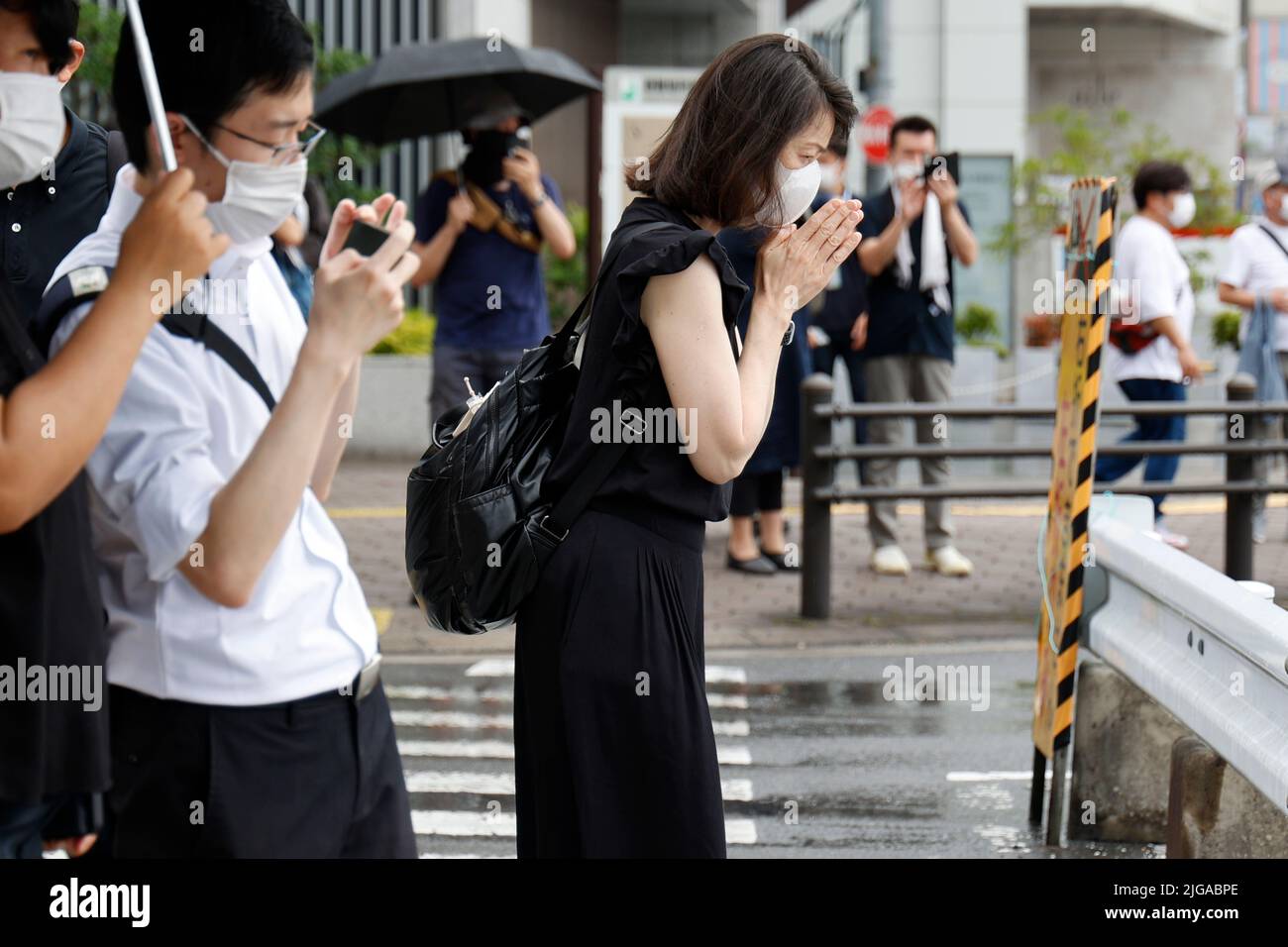 Nara, Nara, Japan. 9th July, 2022. A woman wearing a face mask offers a ...