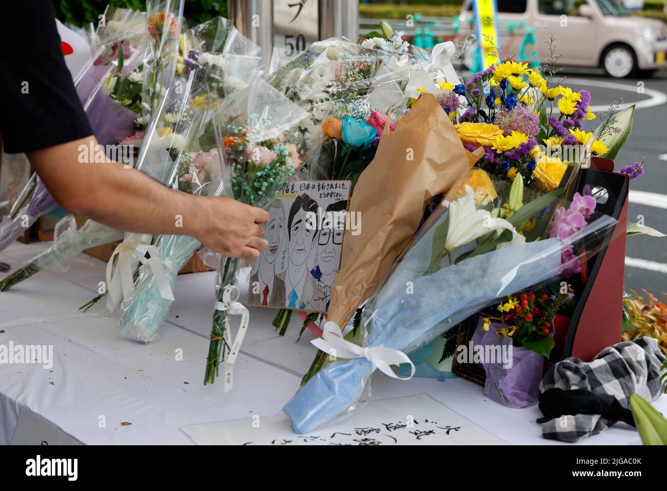 Nara, Nara, Japan. 9th July, 2022. A man leaves flowers at a makeshift ...