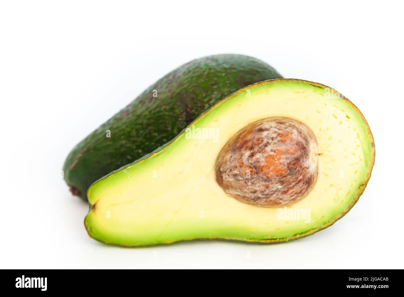 Cut and whole ripe avocadoes on white background Stock Photo - Alamy