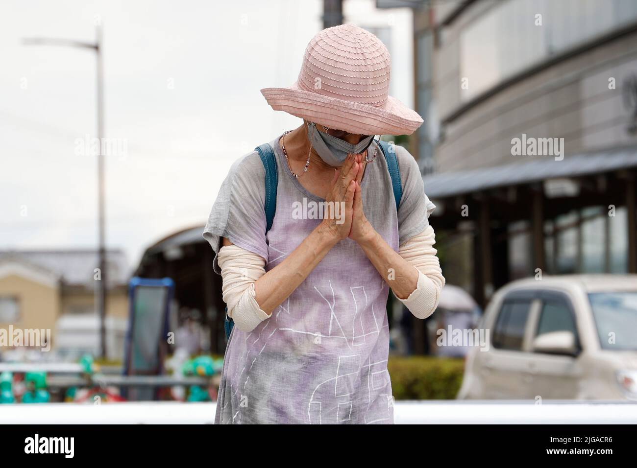Nara, Nara, Japan. 9th July, 2022. A woman wearing a face mask offers a ...