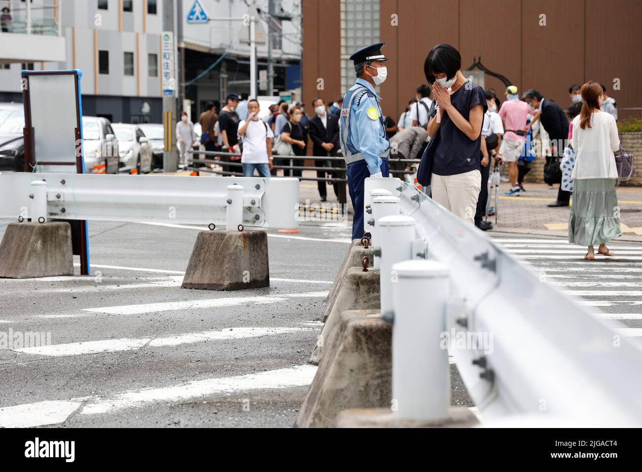 Nara, Nara, Japan. 9th July, 2022. A woman wearing a face mask offers a ...