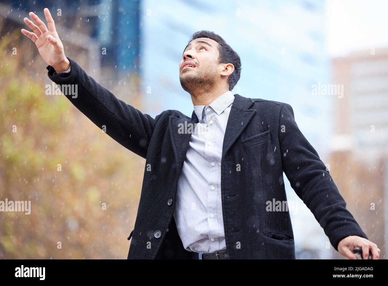 Need a taxi and fast. a handsome young man hailing a taxi in the rain ...