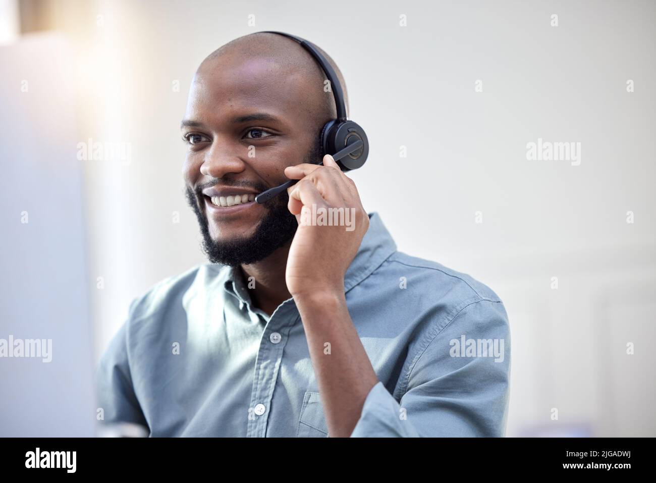 Im ready to be at your service. a young male call center agent working ...
