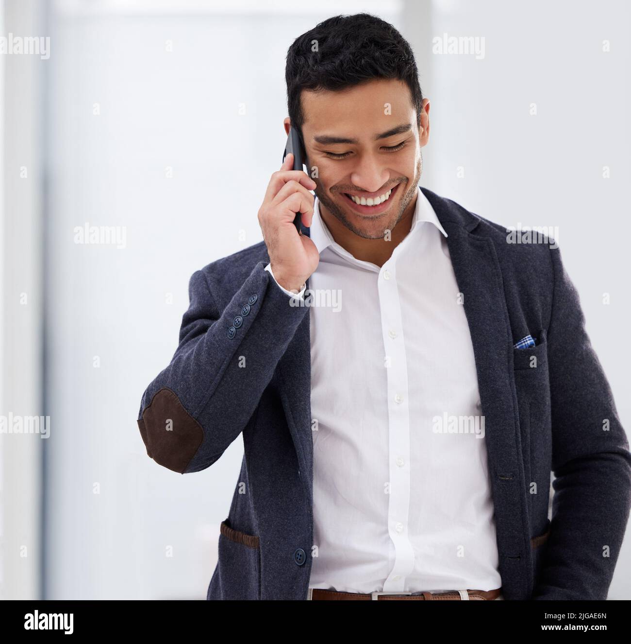Successful calls keep a smile on his face. a young businessman on a ...