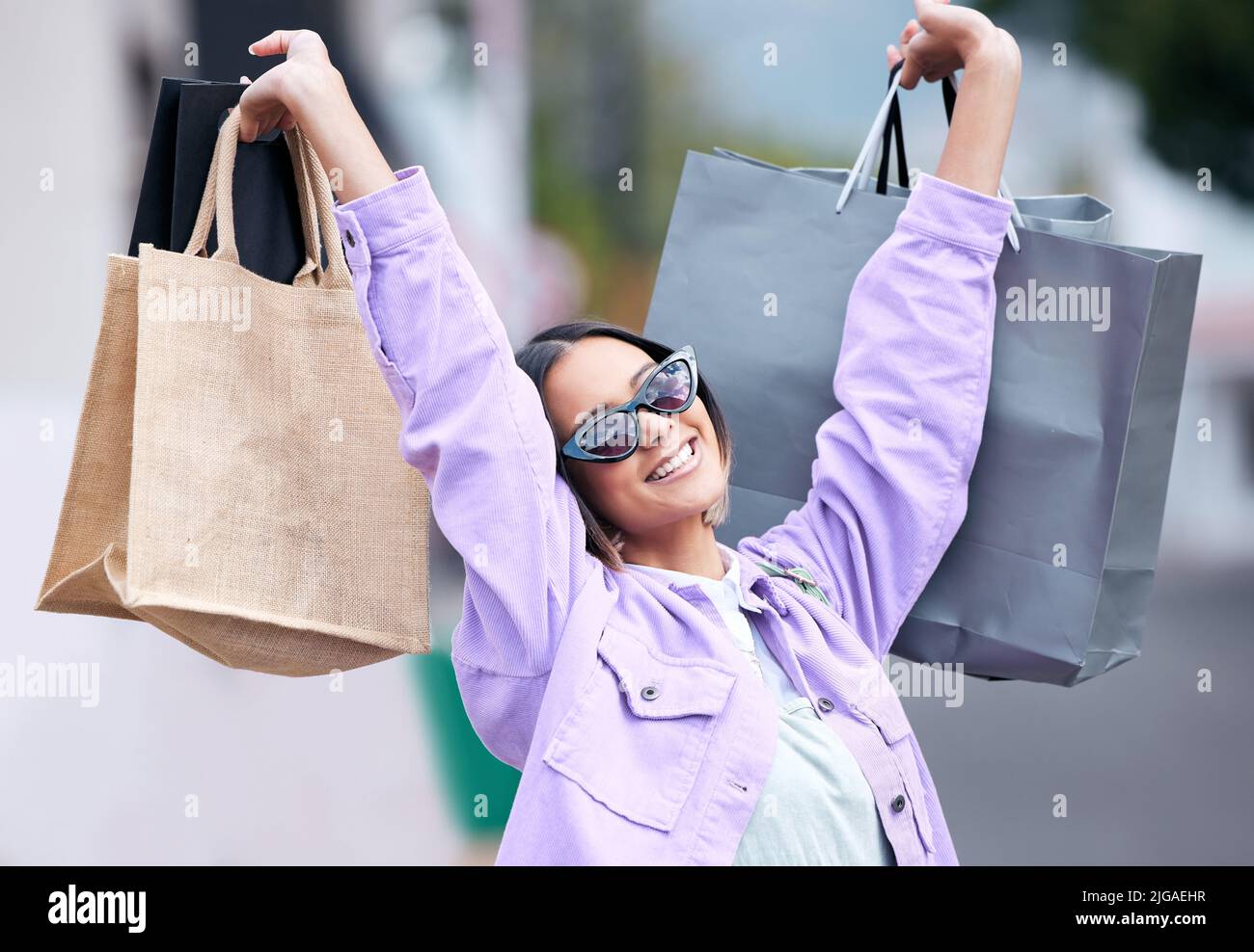 Full bags and empty desires. a young woman out shopping in the city ...