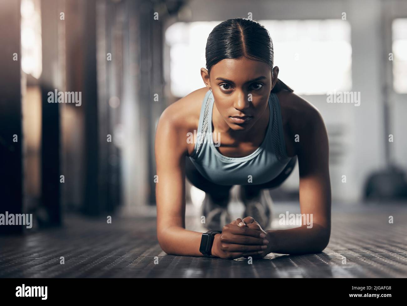 Strong mind, strong body. Portrait of a sporty young woman planking in ...