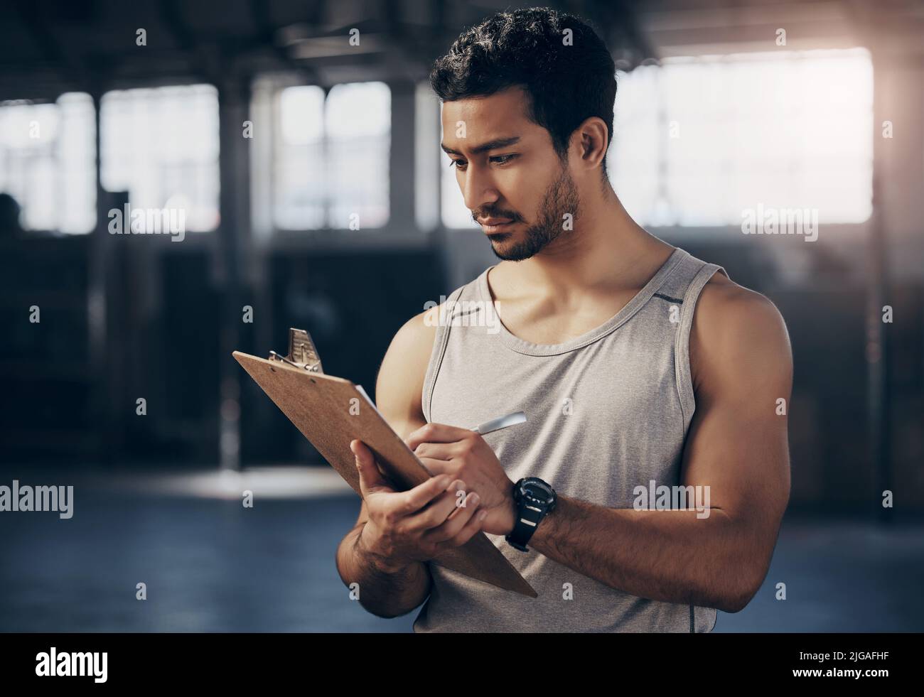 Checking up on his training inventory. a muscular young man writing ...