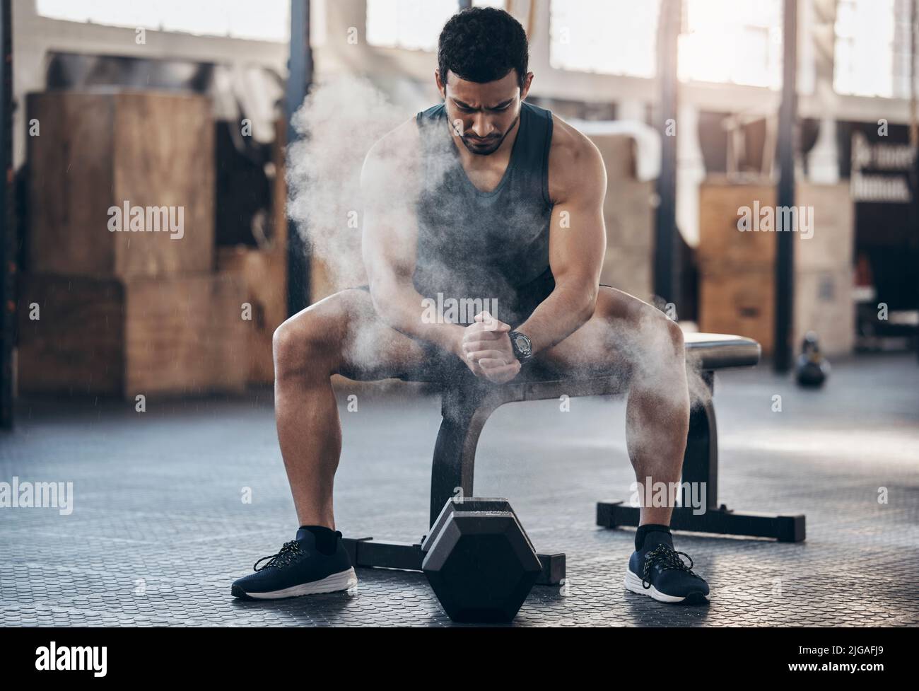 Im ready to rumble. a muscular young man dusting his hands with chalk ...