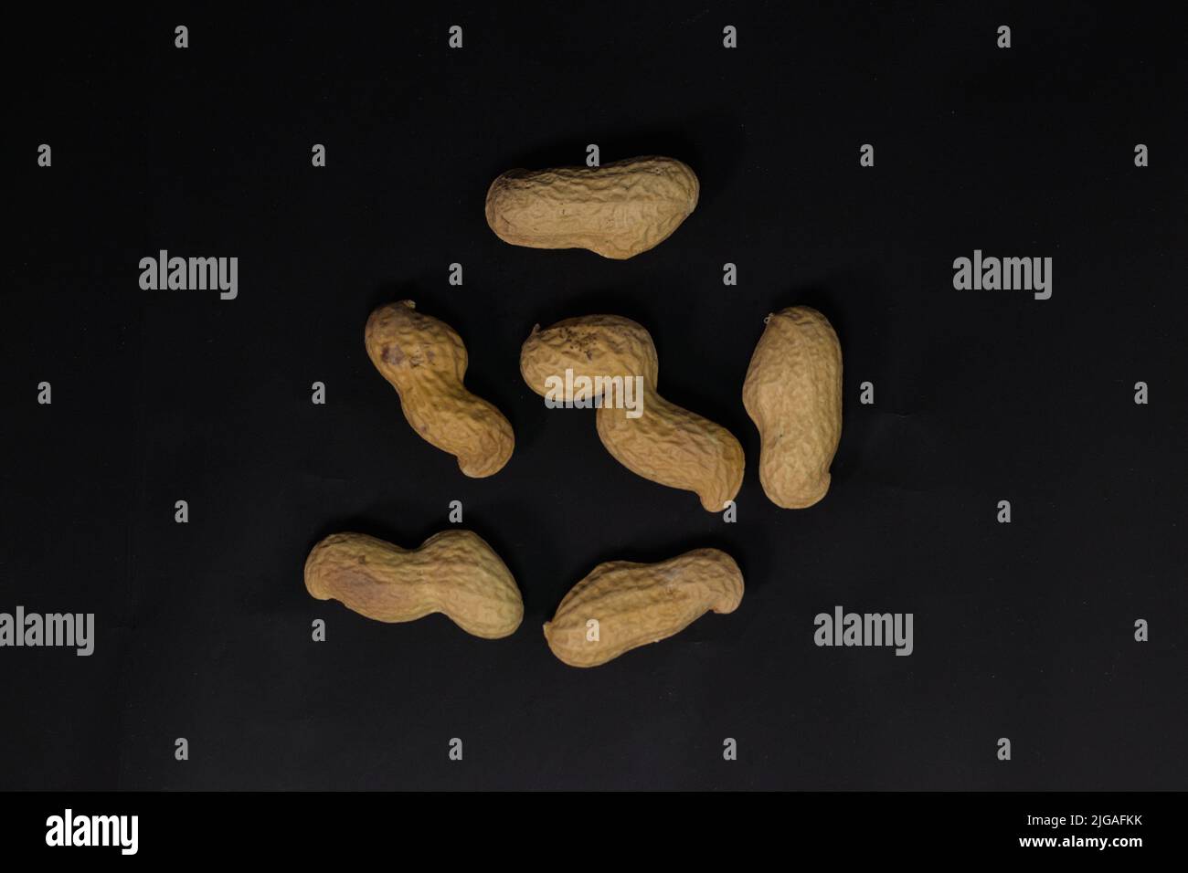 Shelled peanuts scattered on a black surface Stock Photo - Alamy