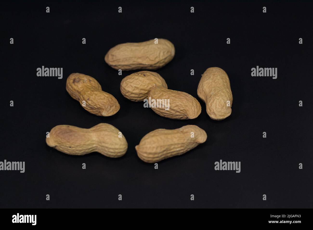 Shelled peanuts scattered on a black surface Stock Photo - Alamy