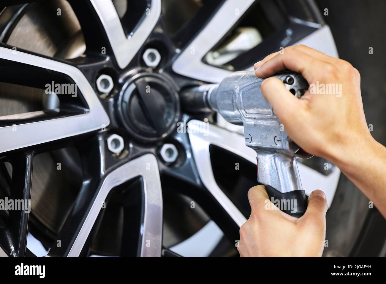 Securing a new fit. an unrecognizable male mechanic fixing a tyre at ...