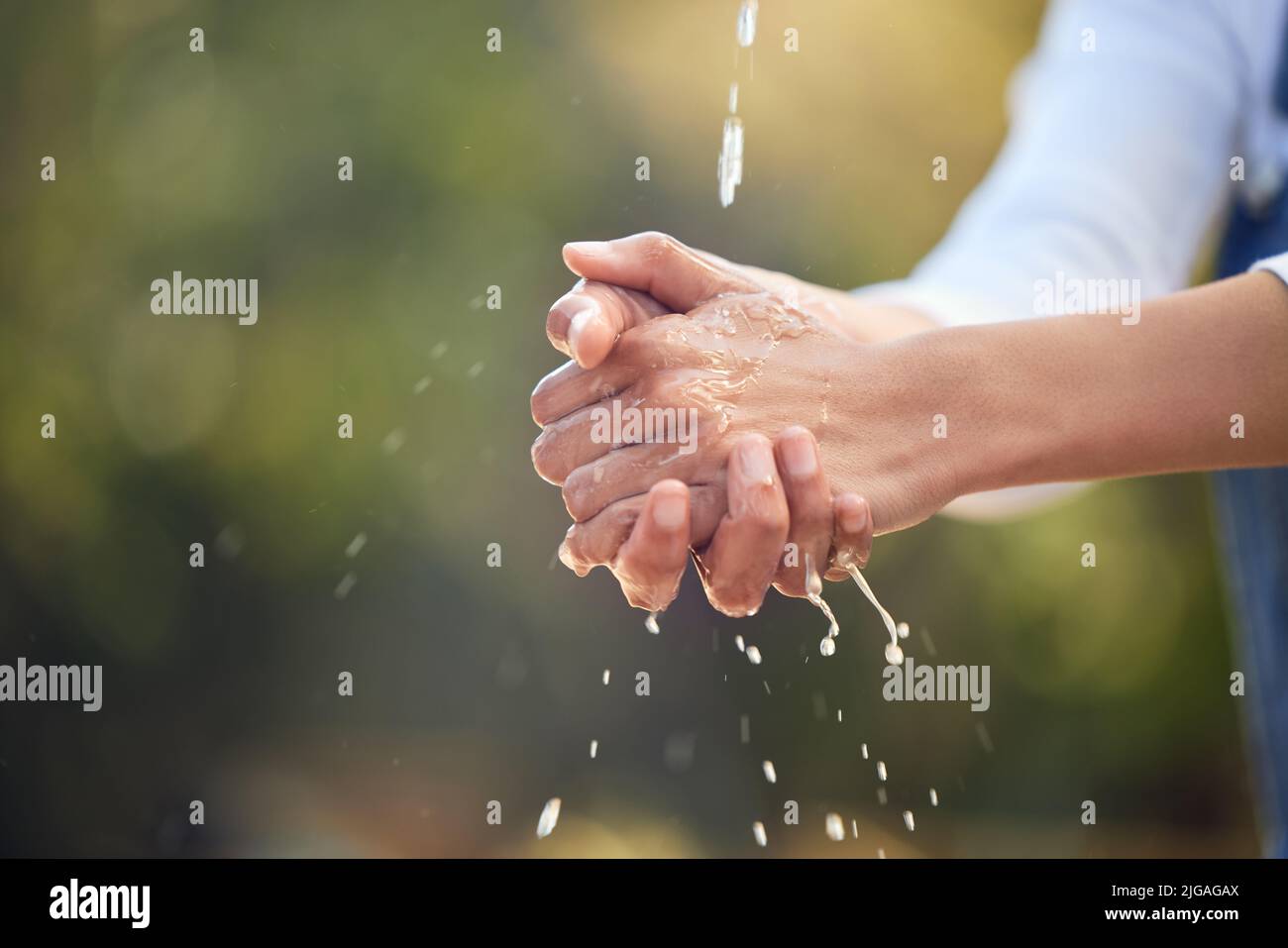 Germs are everywhere. an unrecognizable woman washing her hands outside ...