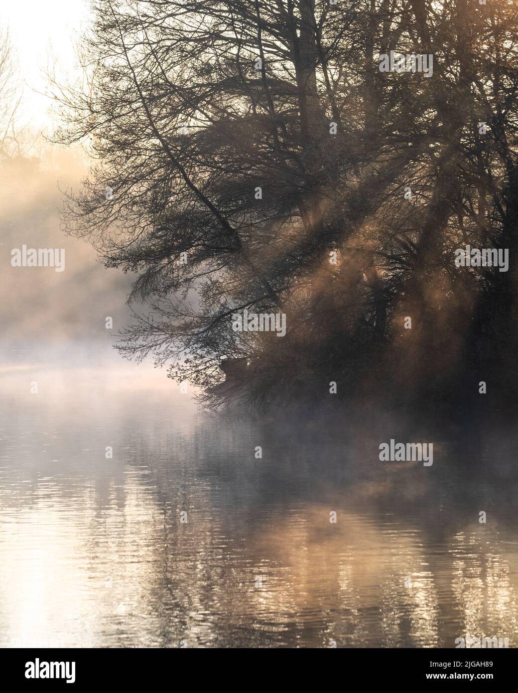 Stunning landscape image of sunrise mist on urban lake with sun beams ...