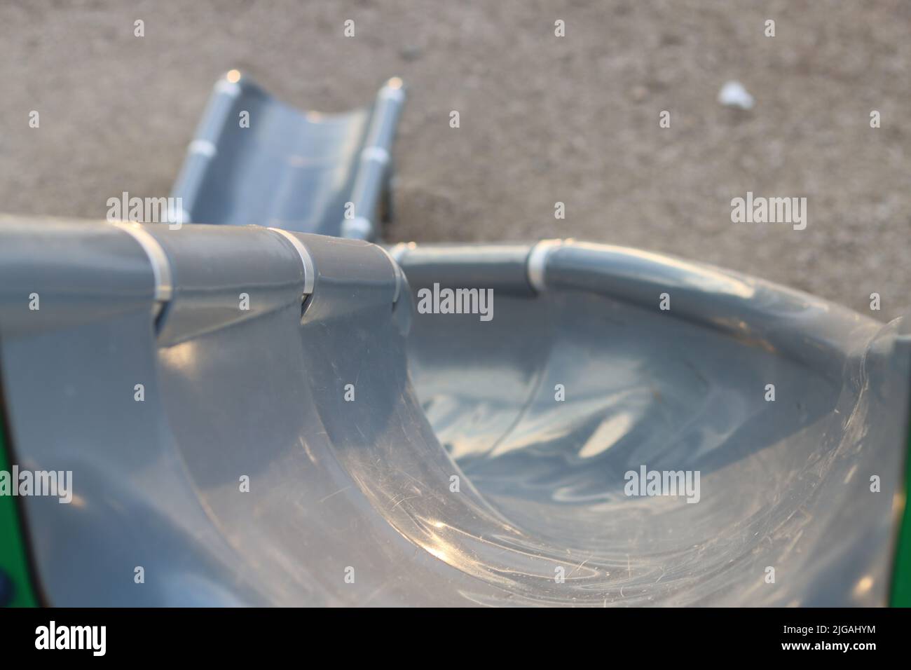 A closeup of gray slide seen on sandy playground Stock Photo - Alamy