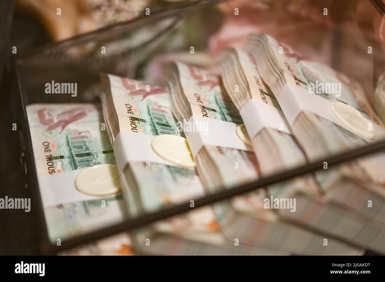 Five bundles of one thousand United Arab Emirates Dirhams, in glass box ...