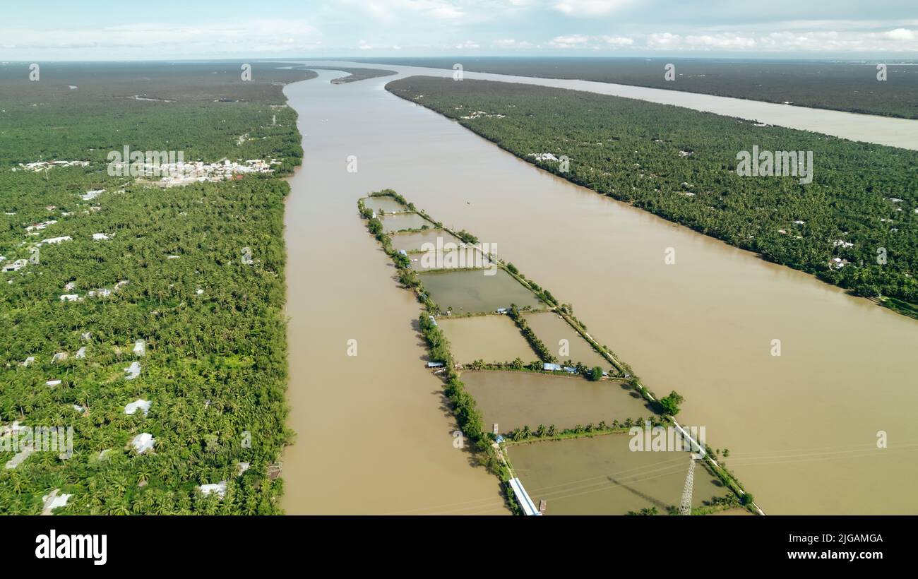 wide aerial panoramic of Ben Tre in Mekong delta with river flowing ...