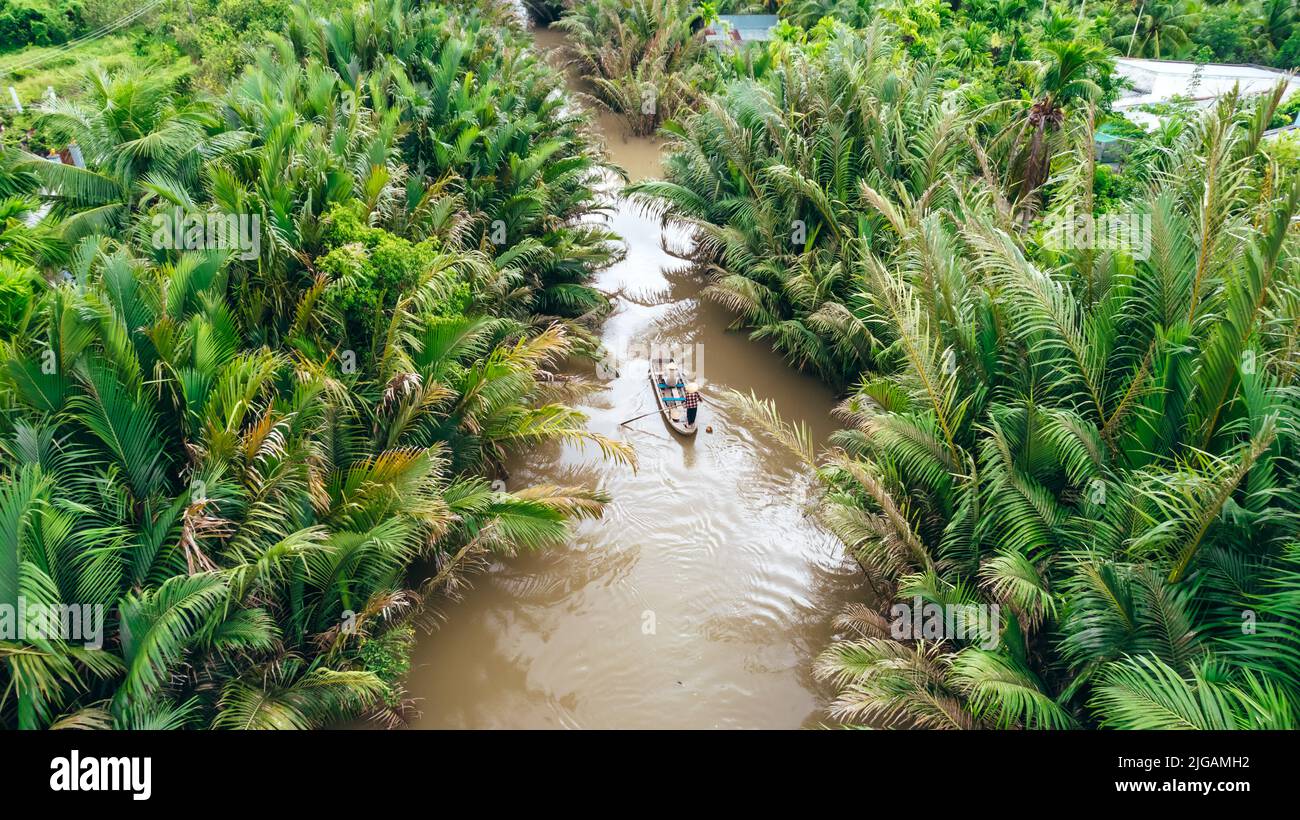 tourist on sampan boat with Vietnamese local paddling on brown river in ...