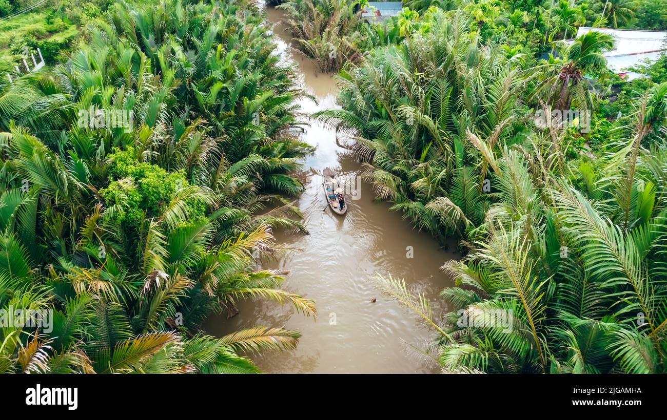 local Vietnamese on sampan paddling down the brown river in the Mekong ...